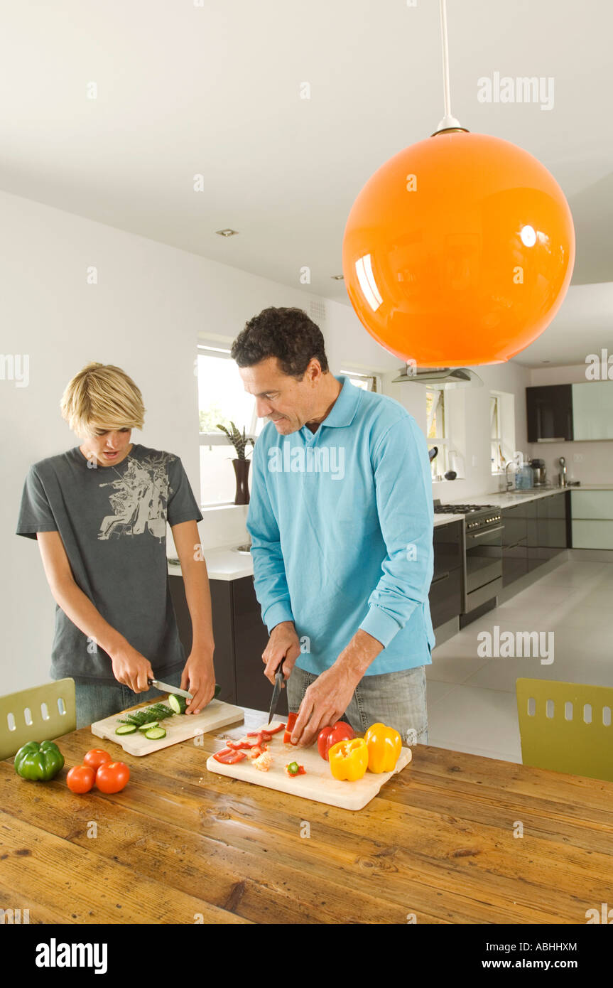 Man and teen boy preparing meal in kitchen Stock Photo - Alamy