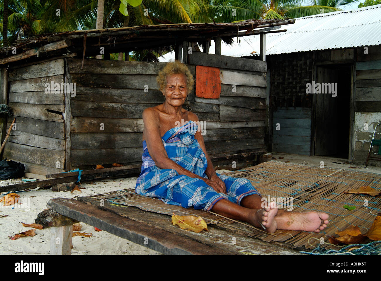 Old woman sitting on a small island in Raja Ampat, Indonesia Stock ...