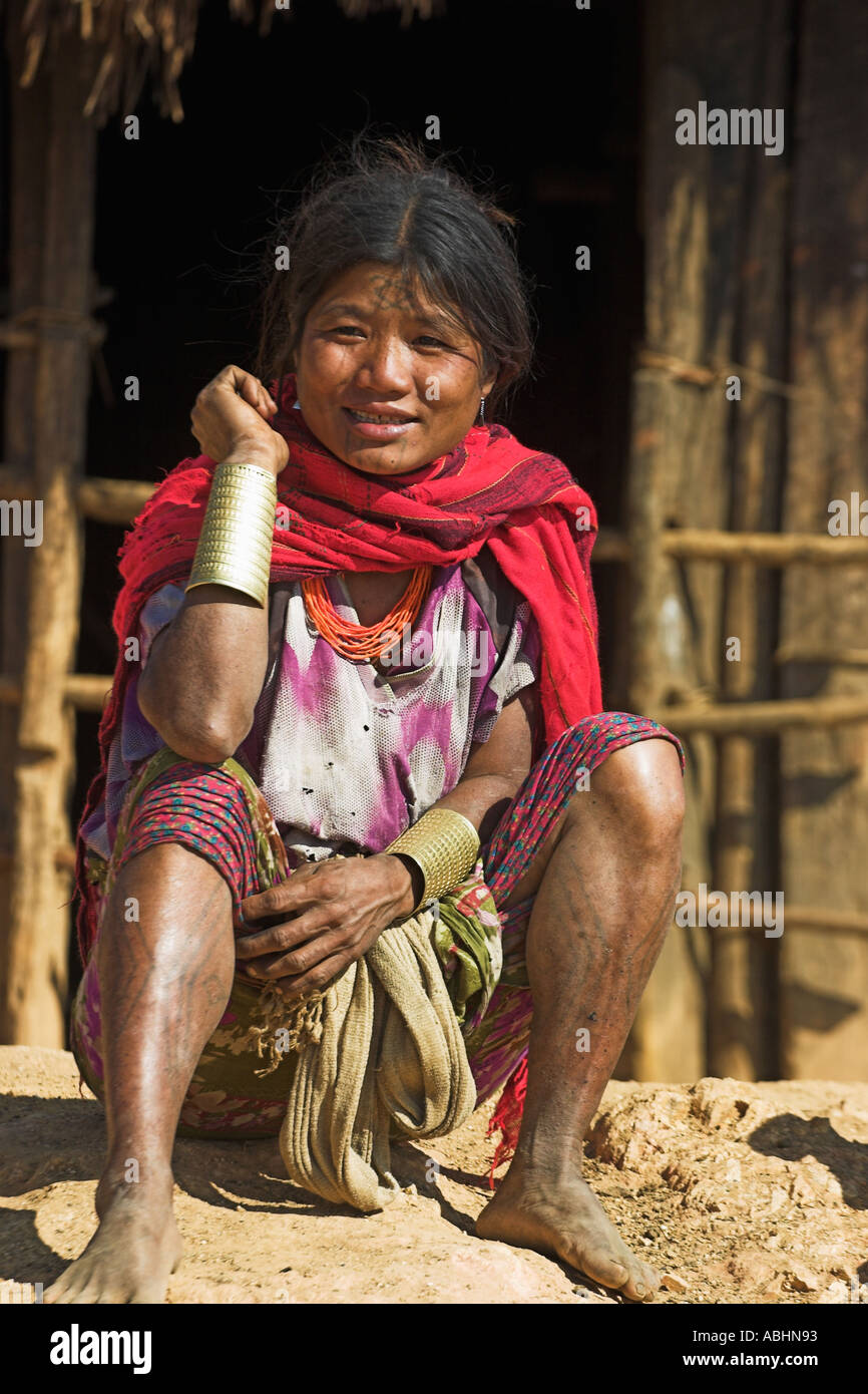 MYANMAR Magyan Village Naga lady with face tatoos sittting outside her ...