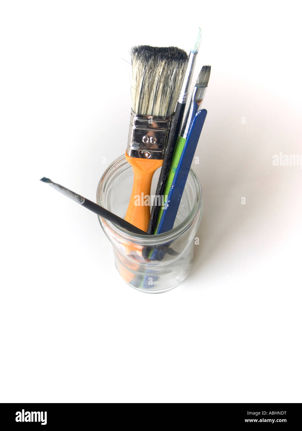 group of various artistic and painter tools in a glass bottle on a ...