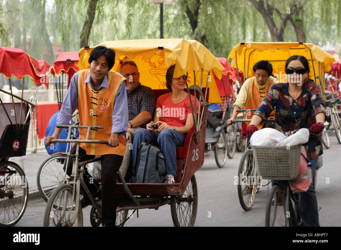 Tourists ride in Cycle Rickshaws along Houhai Lake which give tours of ...