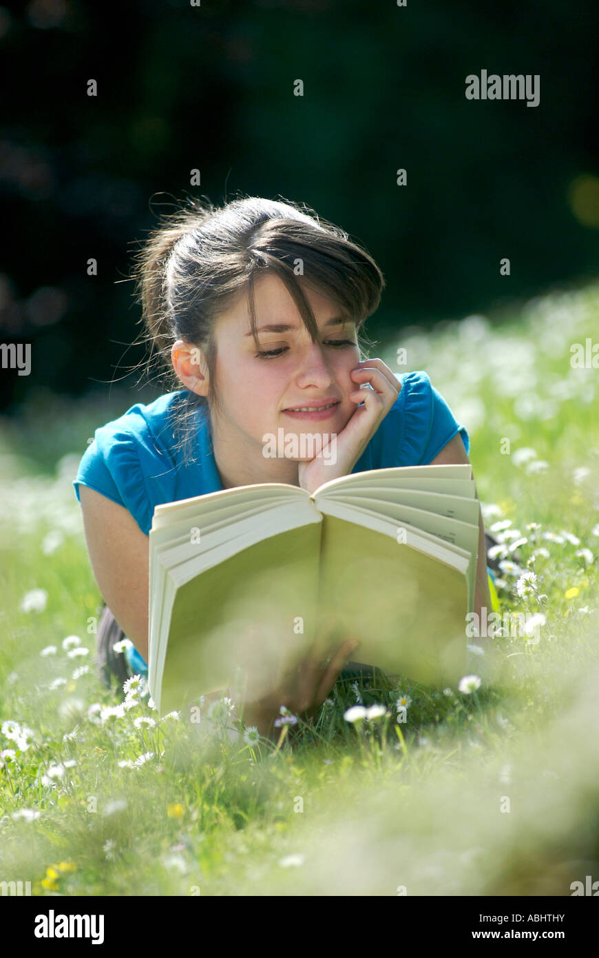 Teenage girl reading / revising outside Stock Photo - Alamy