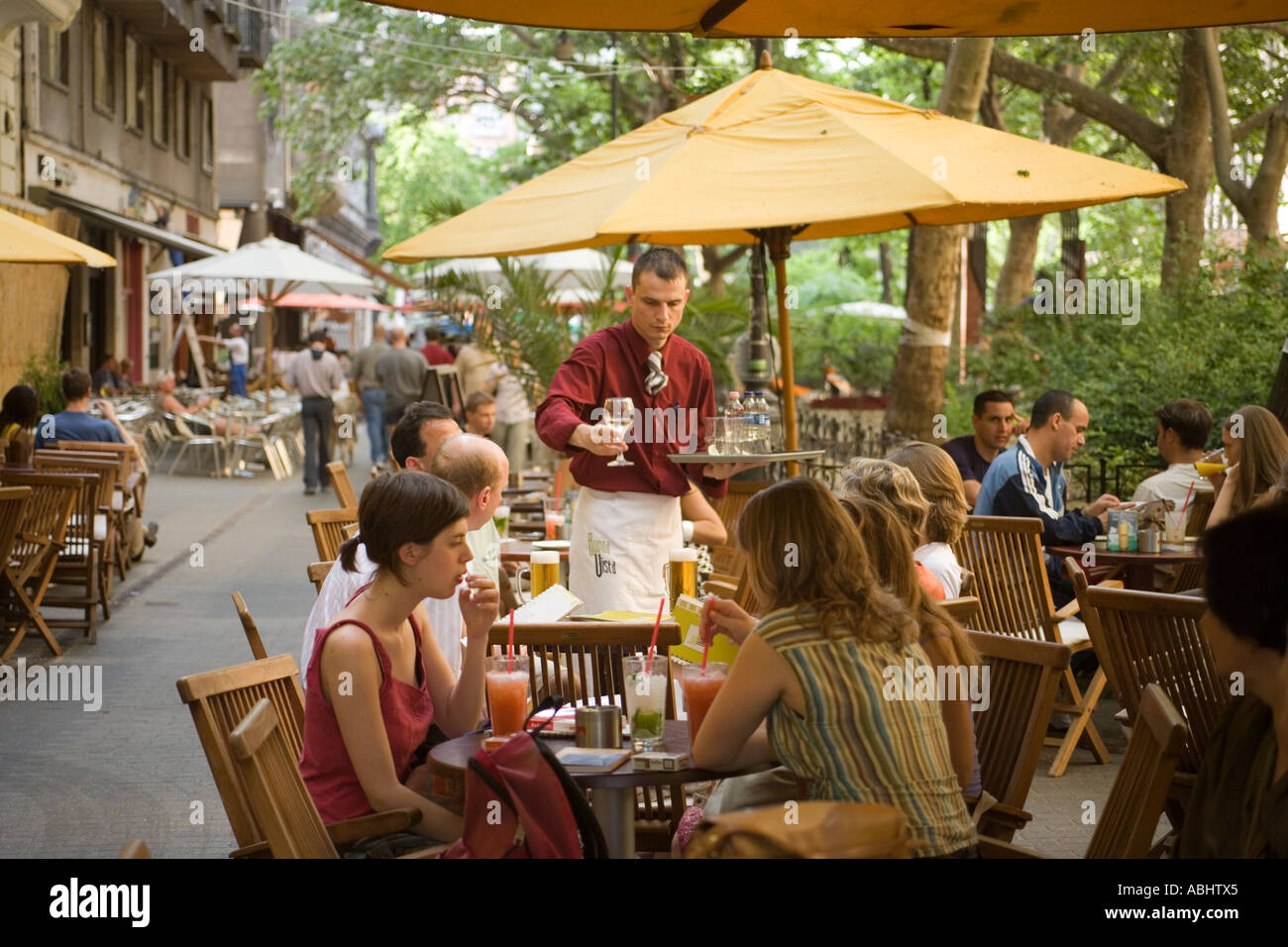 Waiter serving something to drink in an open air cafe at Liszt Square ...