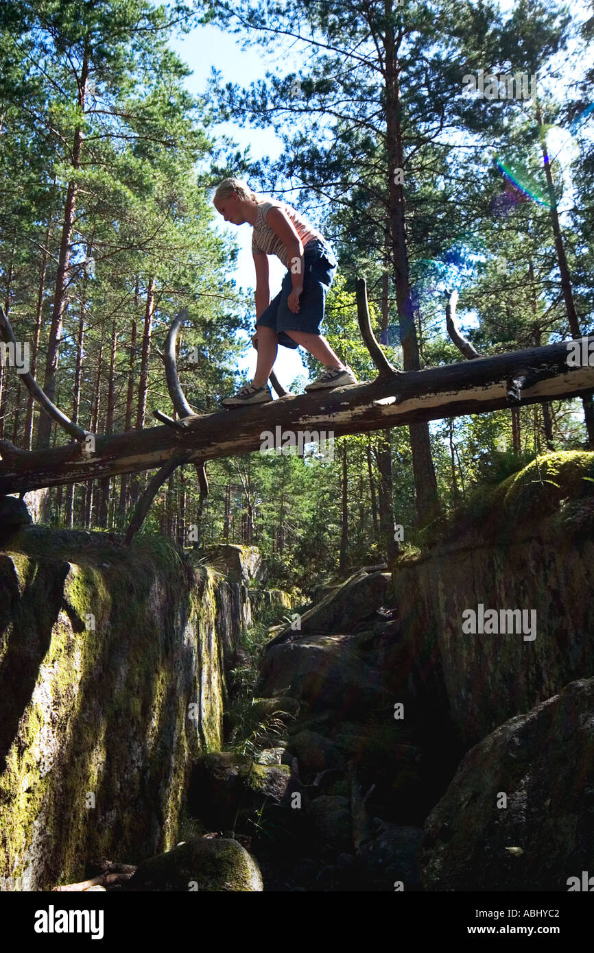ten year old girl walking on a fallen tree across a crevasse Stock ...