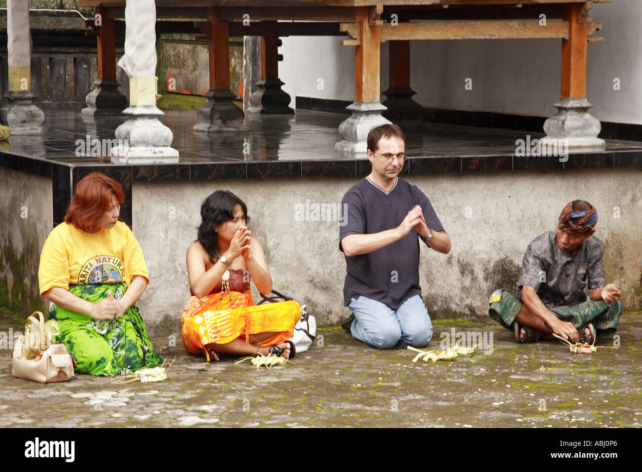 Tourists learning to pray at besakih temple hi-res stock photography ...
