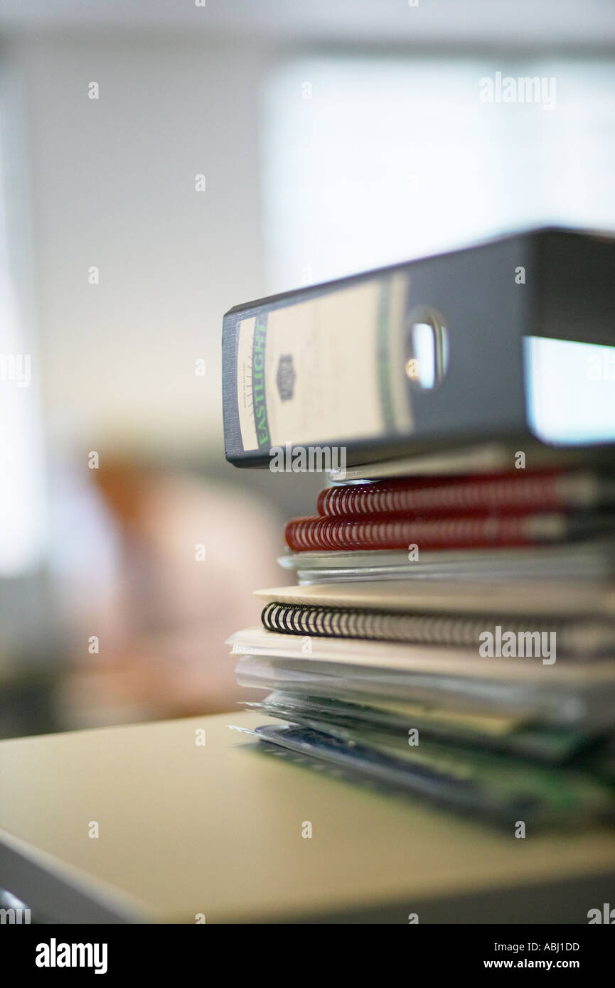 files piled on desk in open plan office Stock Photo - Alamy