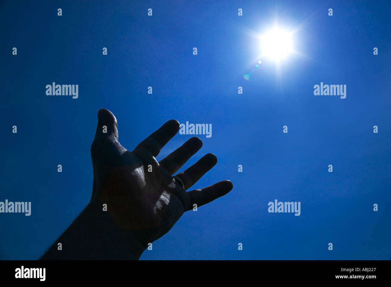 Hand spread to shade bright burning sun in blue sky Stock Photo - Alamy