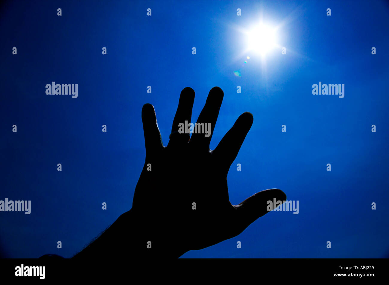 Hand spread to shade bright burning sun in blue sky Stock Photo - Alamy