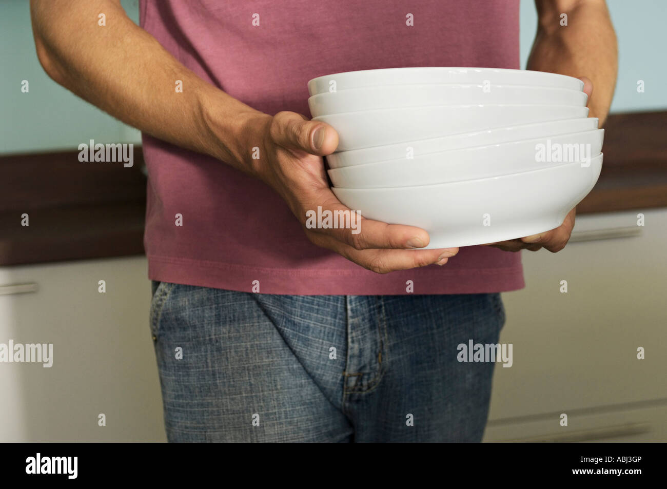 Young man carrying stack of plates Stock Photo - Alamy