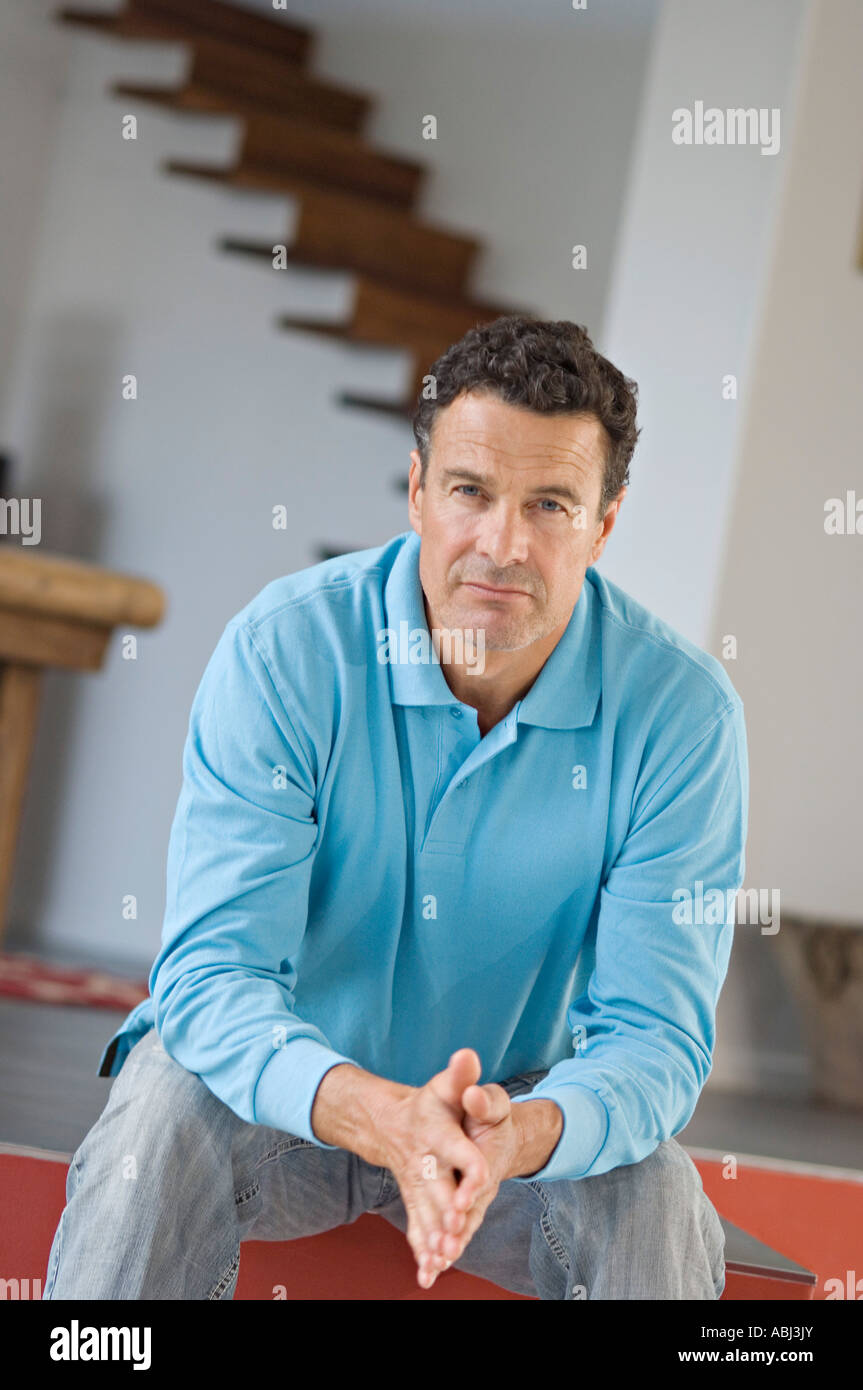 Man sitting, joining hands Stock Photo - Alamy