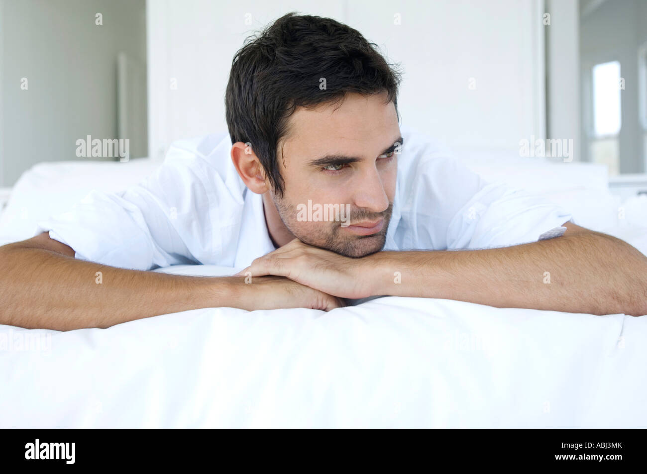 Young thinking man lying on bed Stock Photo - Alamy