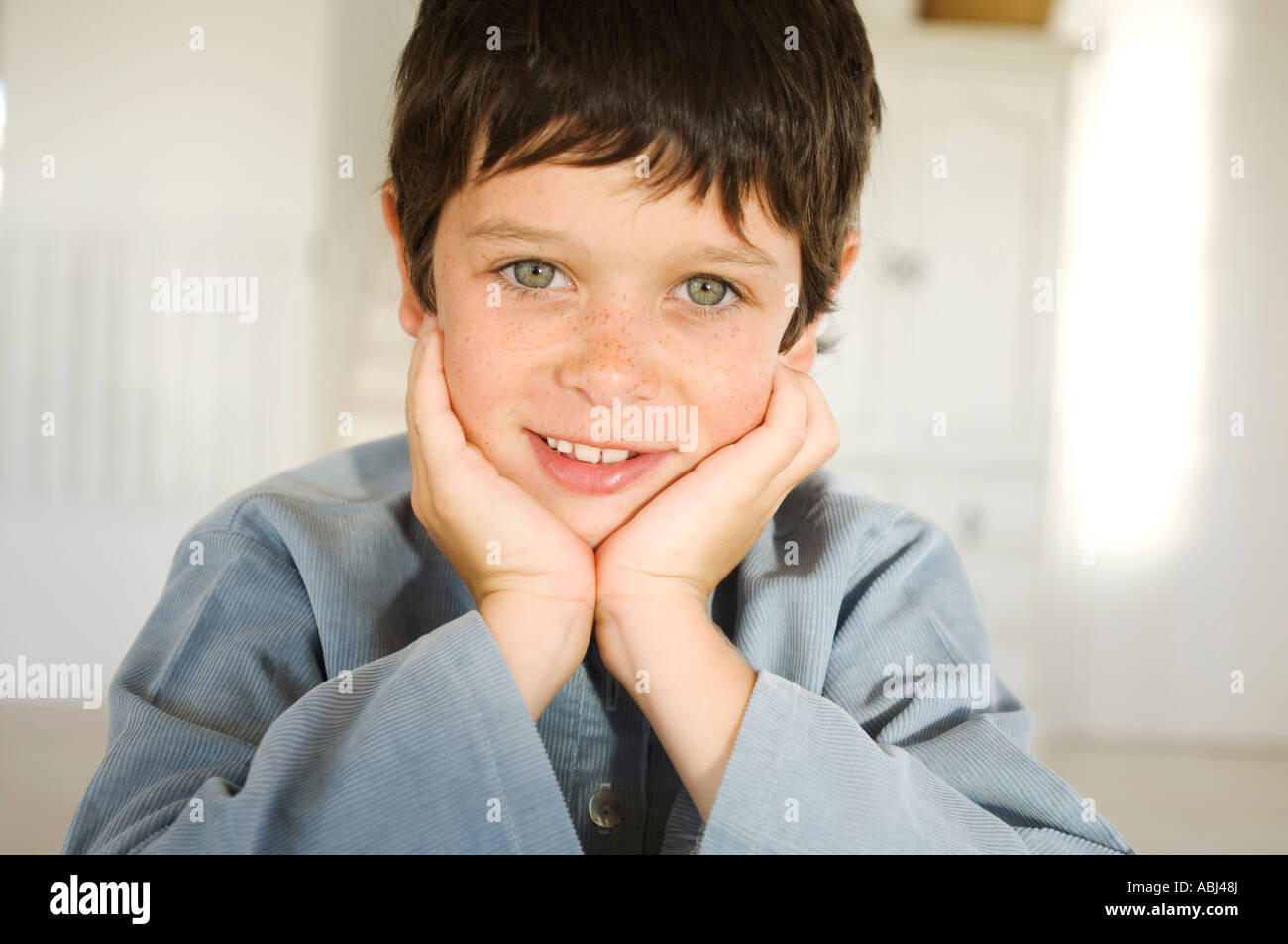 Portrait of little boy with hands on chin Stock Photo - Alamy