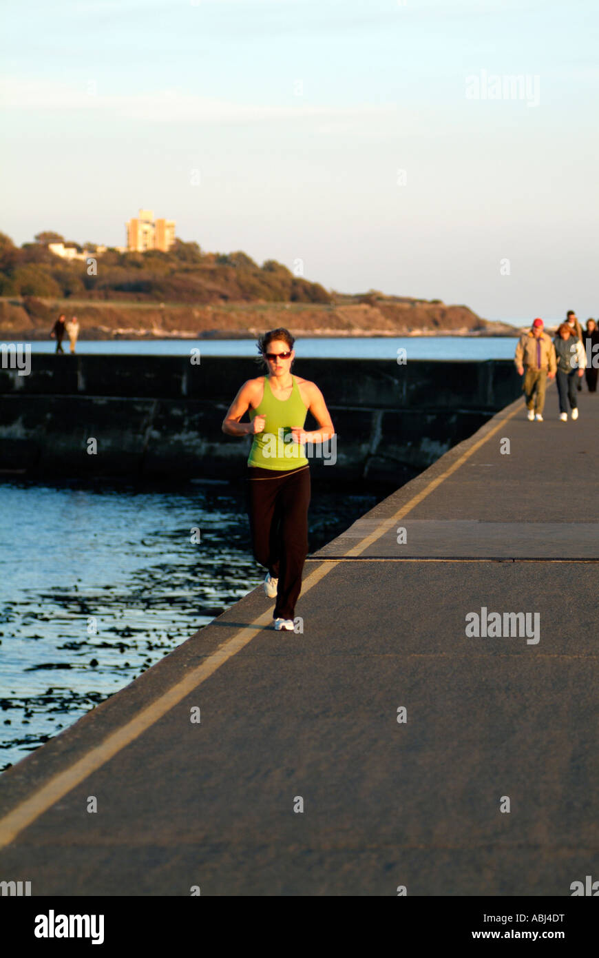 Woman running on a jetty in Victoria Stock Photo - Alamy