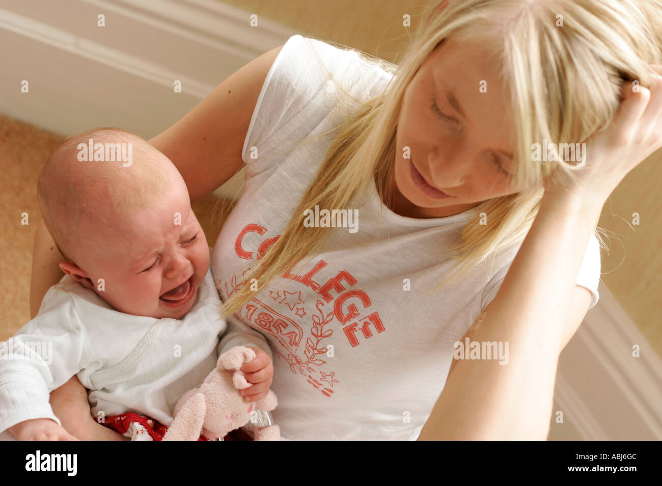 teenager with crying baby looking stressed Stock Photo - Alamy
