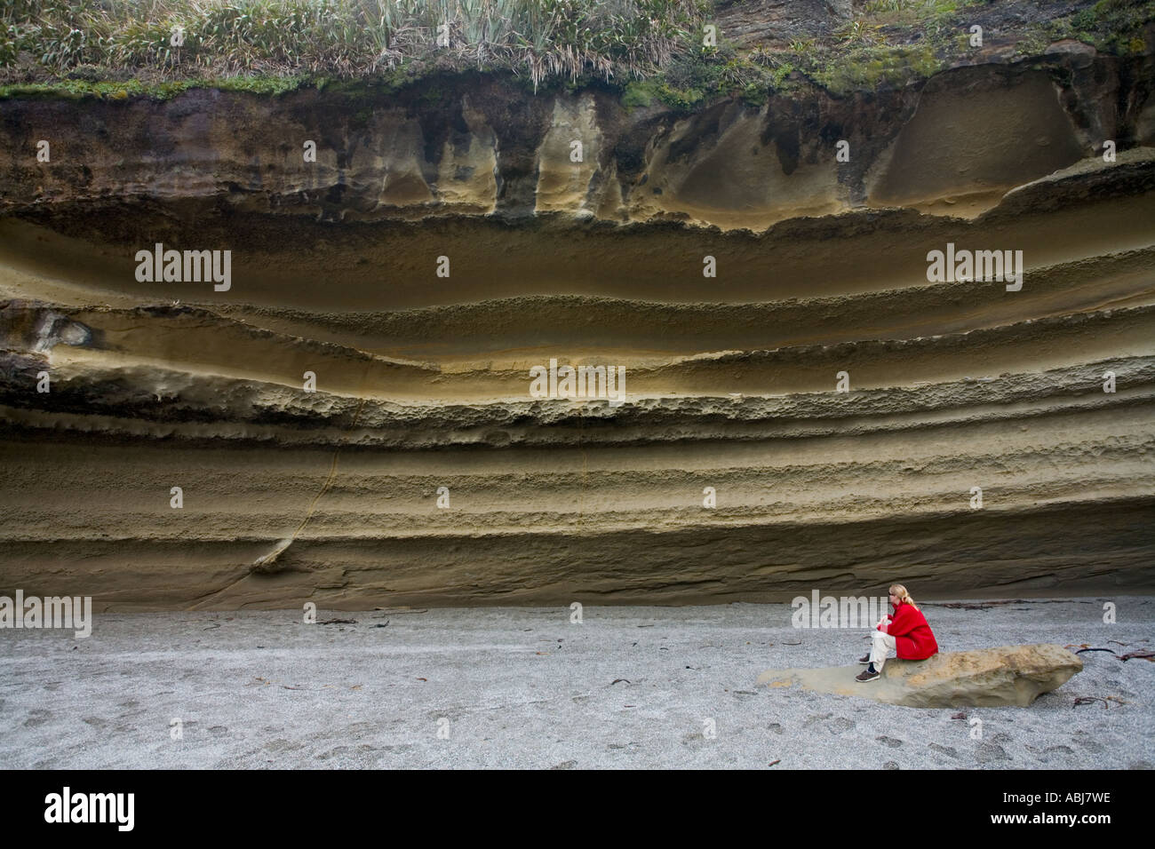 A person viewing the sedimentary layers of a cliff face Stock Photo - Alamy