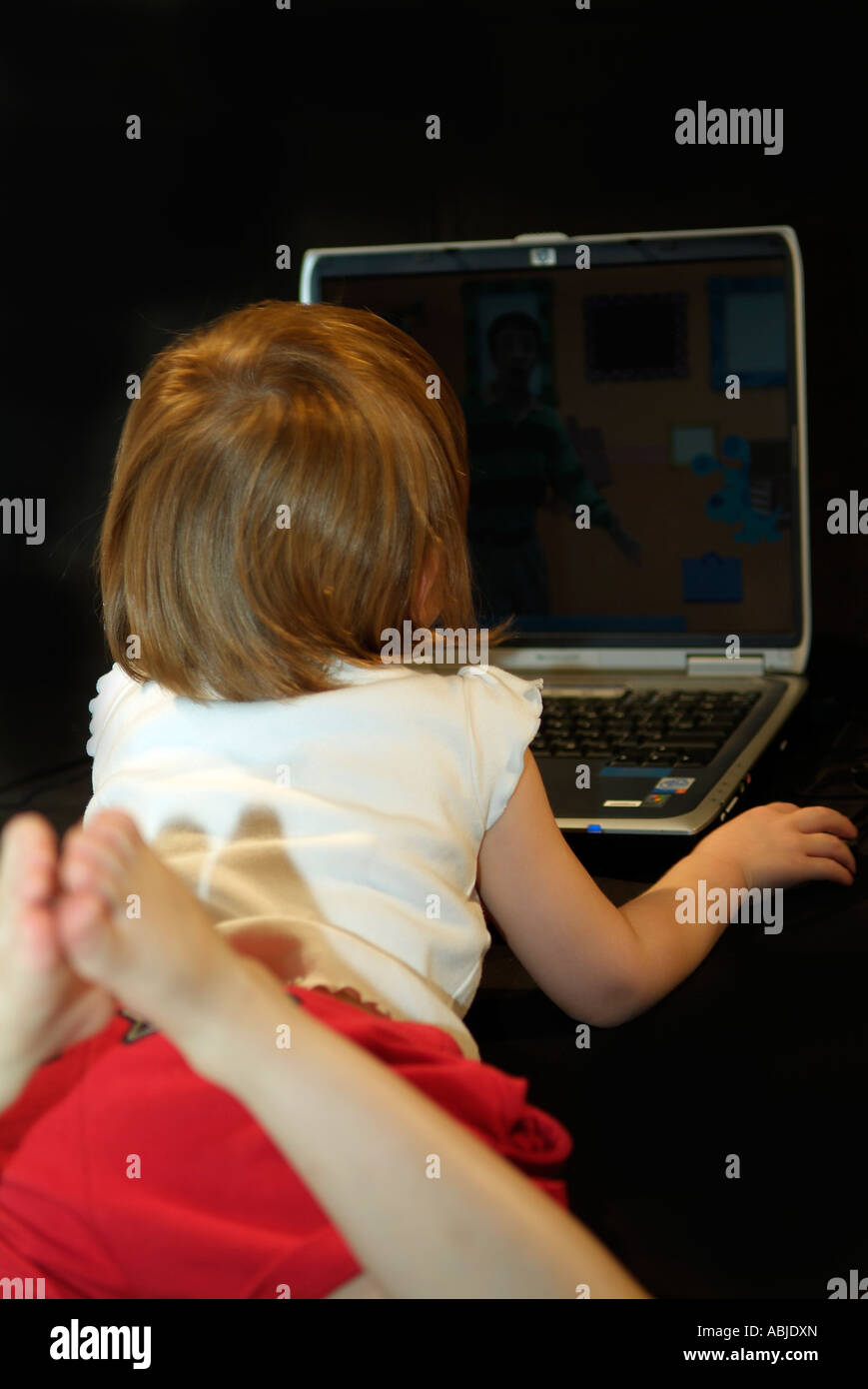 Young girl watching the screen of a laptop computer Stock Photo - Alamy