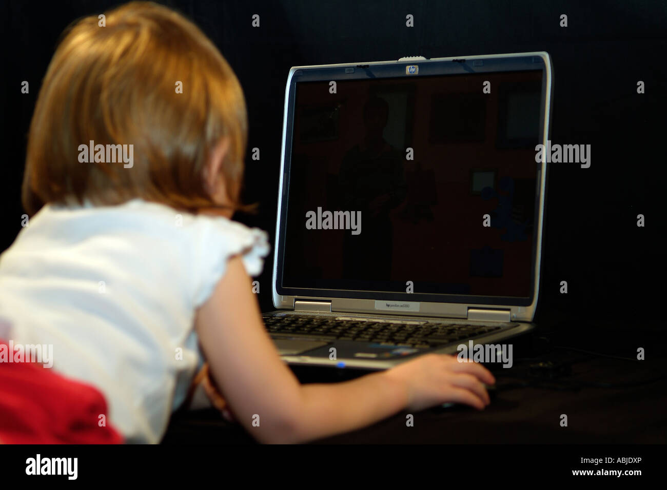 Young girl watching the screen of a laptop computer Stock Photo - Alamy