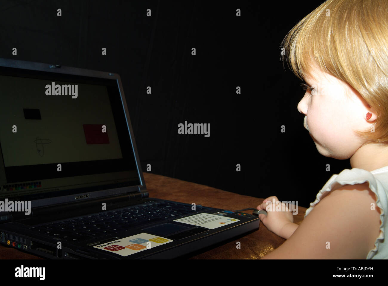 Young girl watching the screen of a laptop computer Stock Photo - Alamy