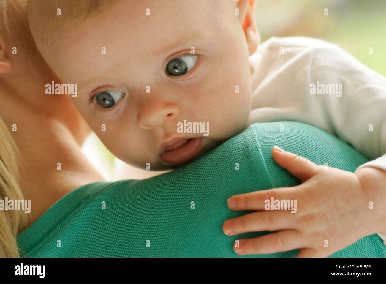 Baby looking over mothers shoulder Stock Photo - Alamy
