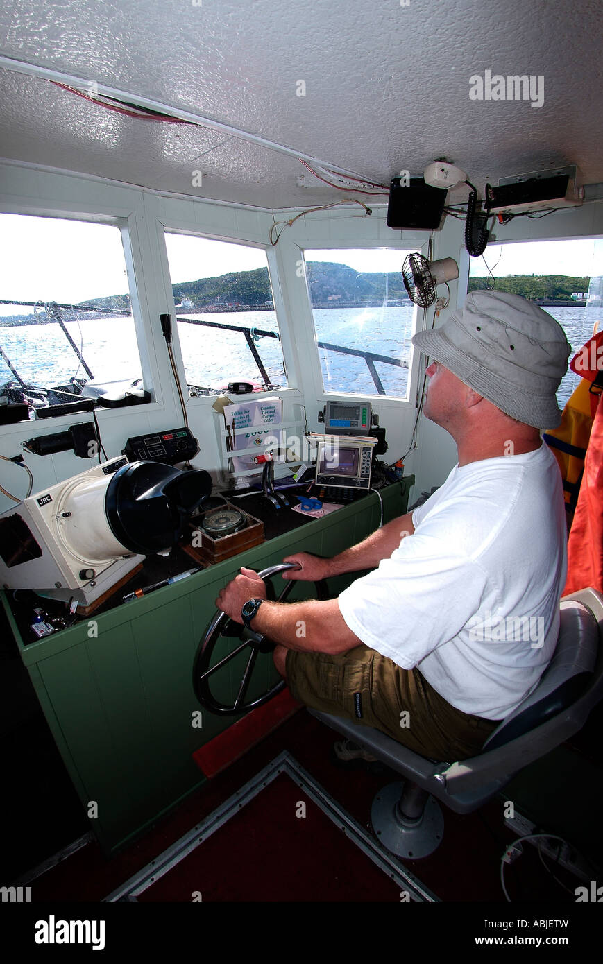 Man piloting a diving boat on the Saint Lawrence river Stock Photo - Alamy