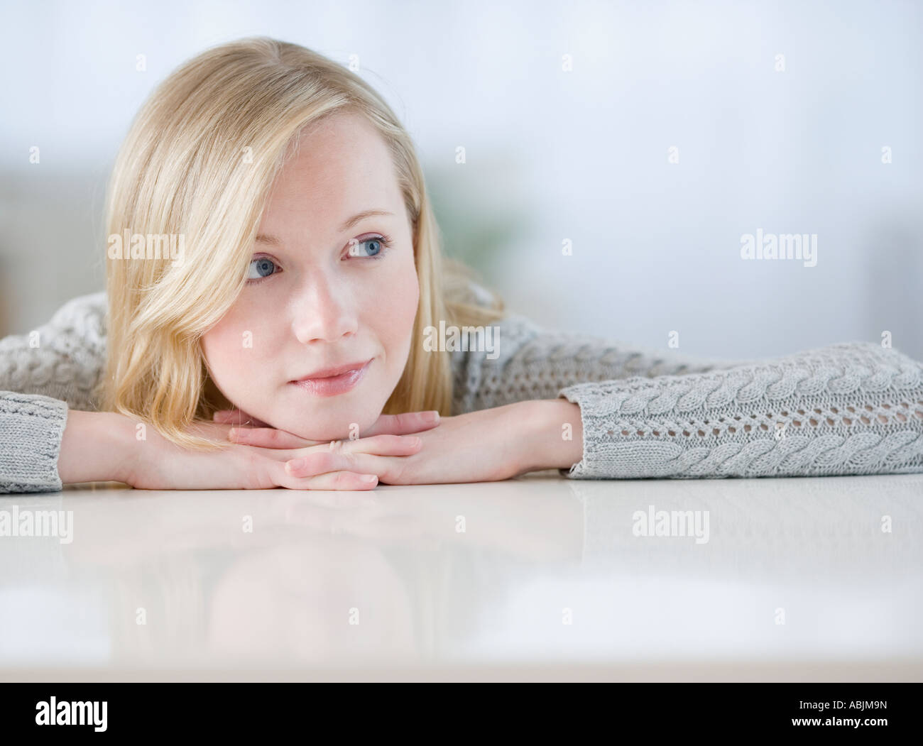 Woman leaning chin on hands Stock Photo - Alamy