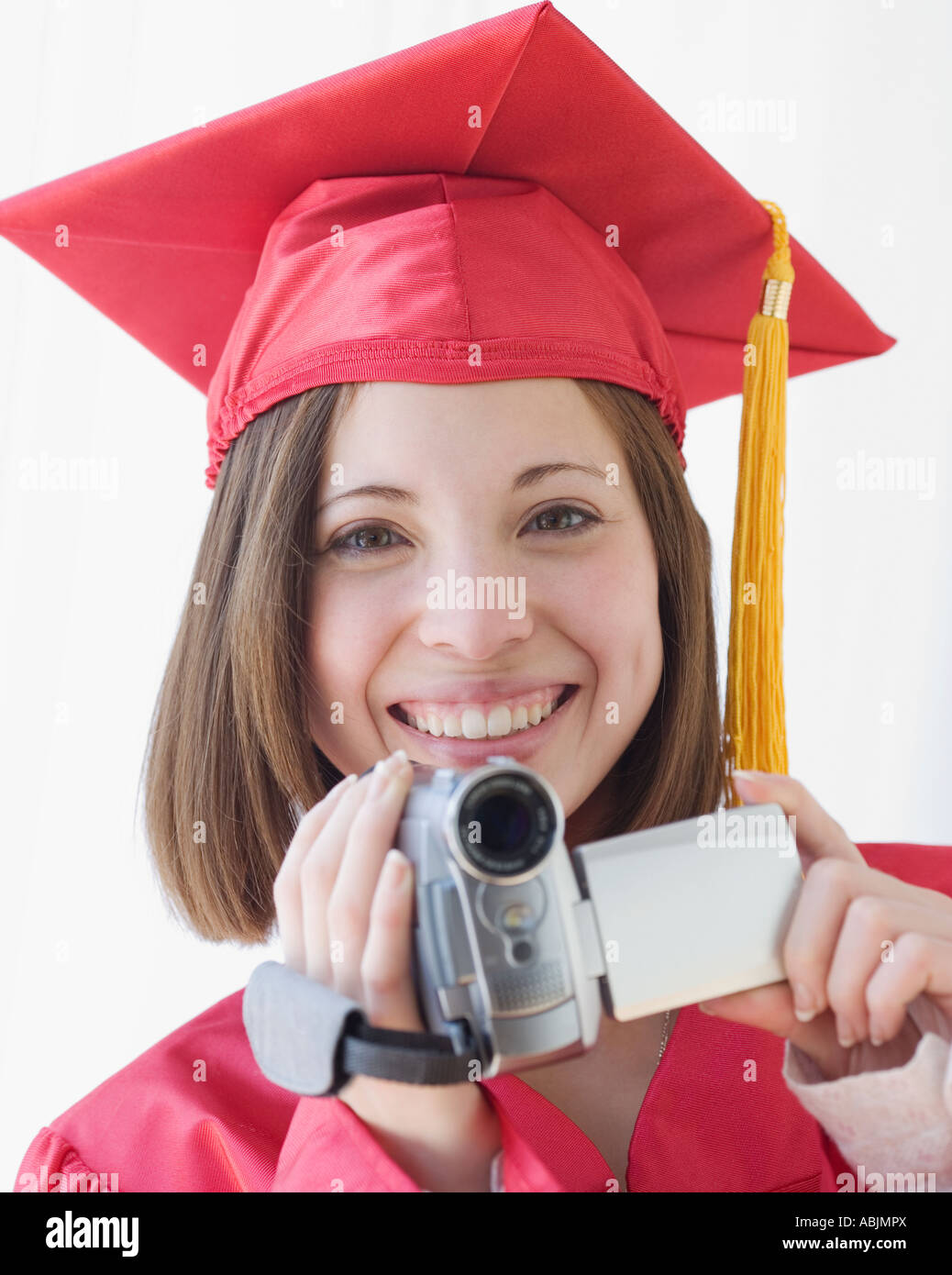 Female graduate holding video camera Stock Photo - Alamy