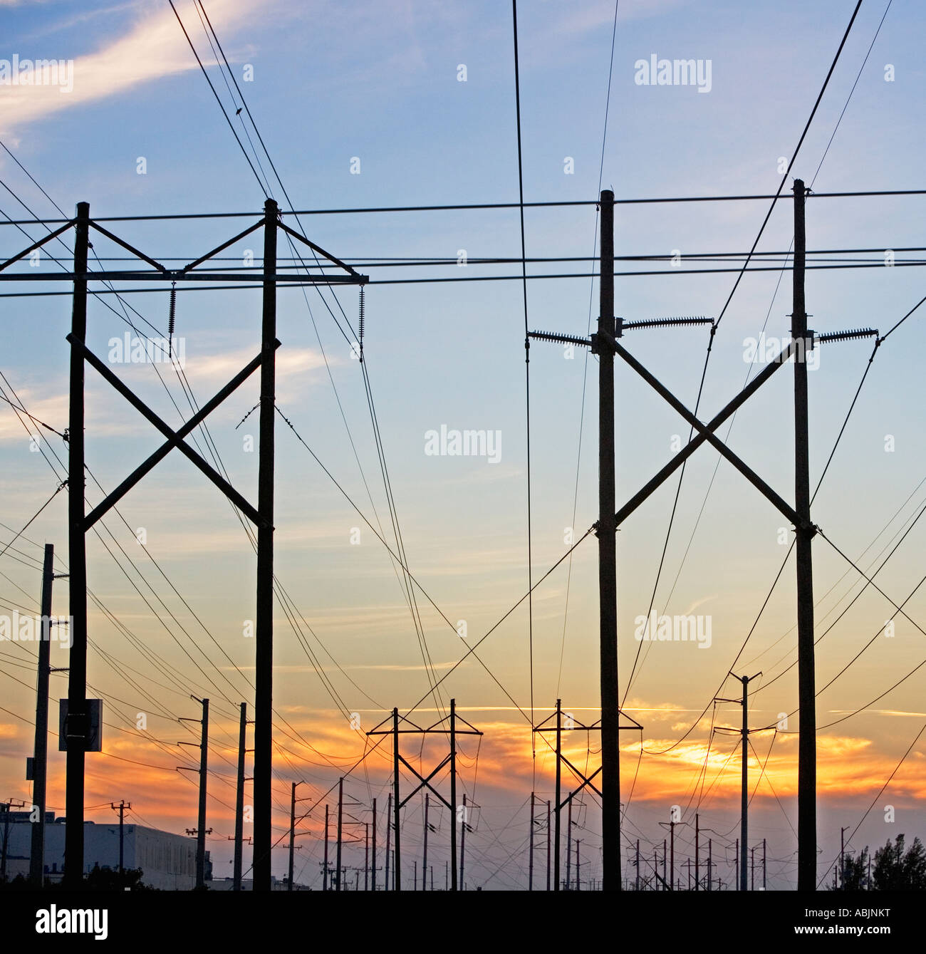 Electrical poles and wires at sunset Stock Photo - Alamy