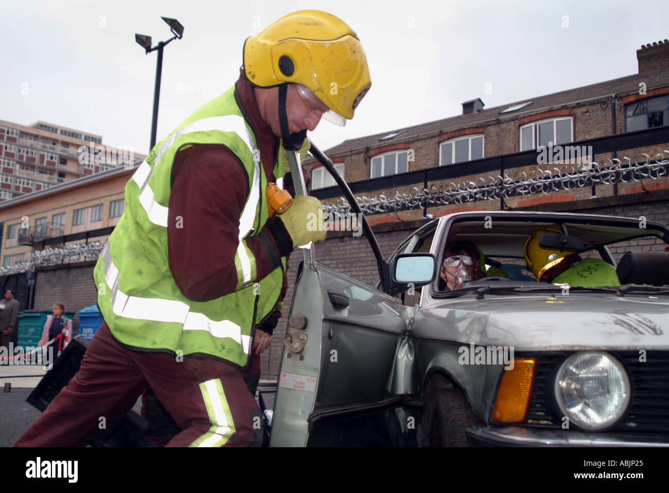 FIRE BRIGADE ON DUTY RESCUEING A CAR ACCIDENT VICTIM FROM WRECKED CAR ...