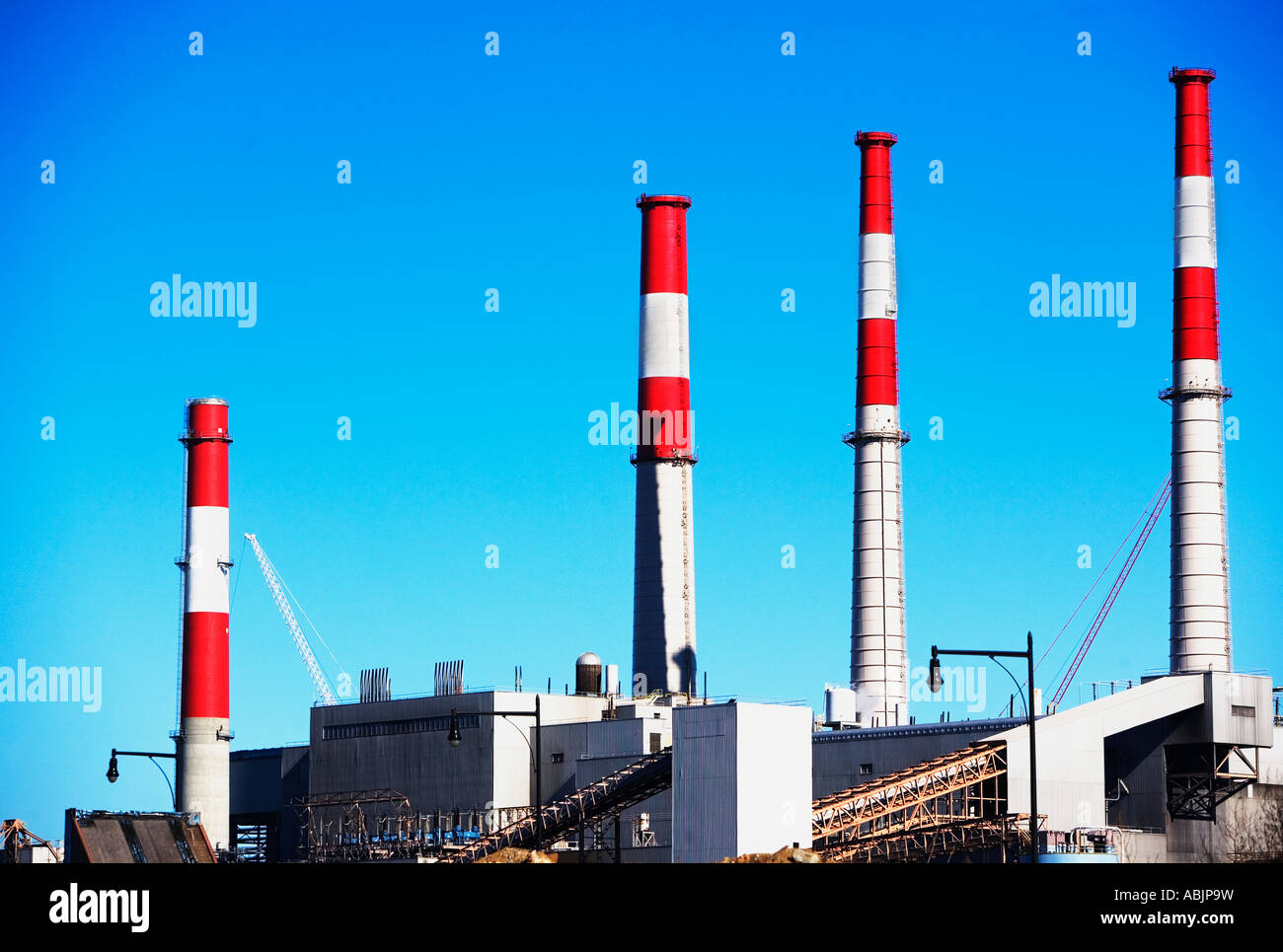 Factory with smoke stacks under blue sky Stock Photo - Alamy