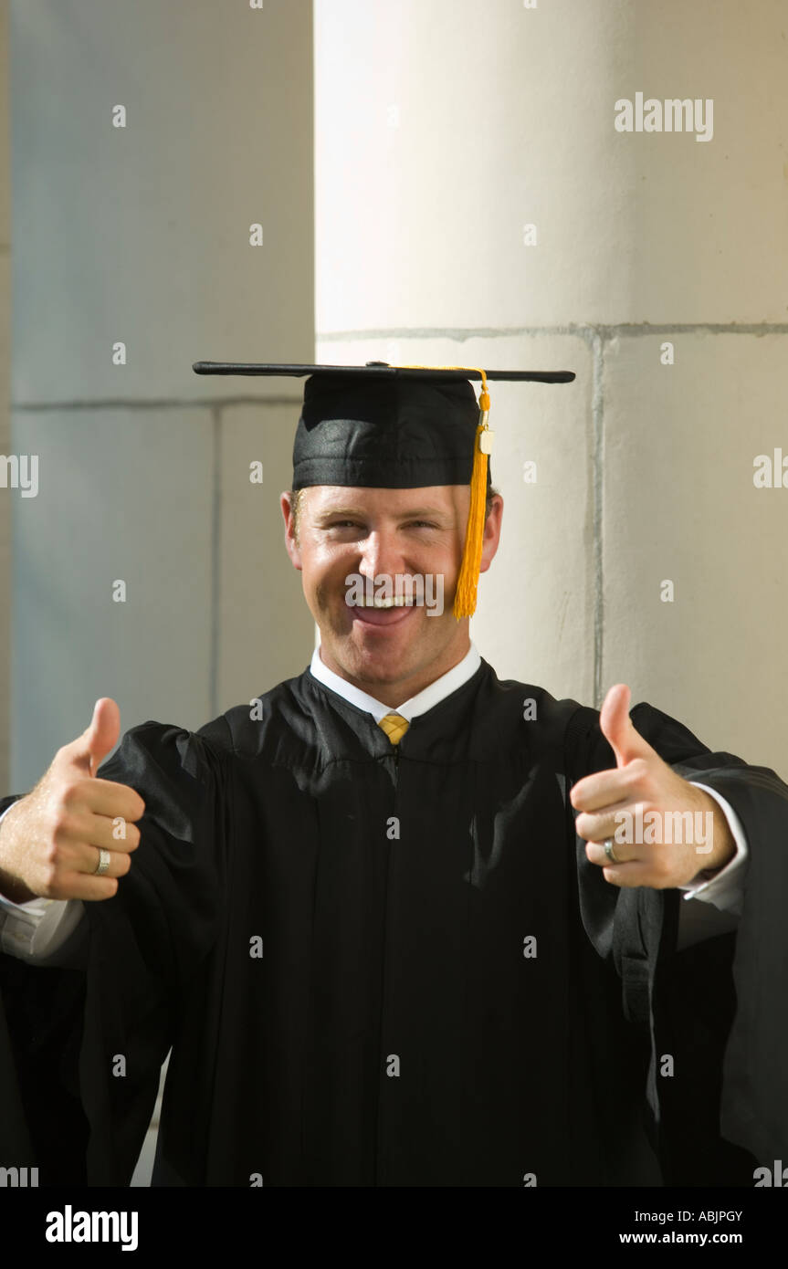 Male graduate giving thumbs up Stock Photo - Alamy
