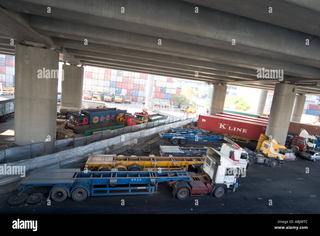 trucks lorry lorries under highway overpass stock yard waiting to load ...