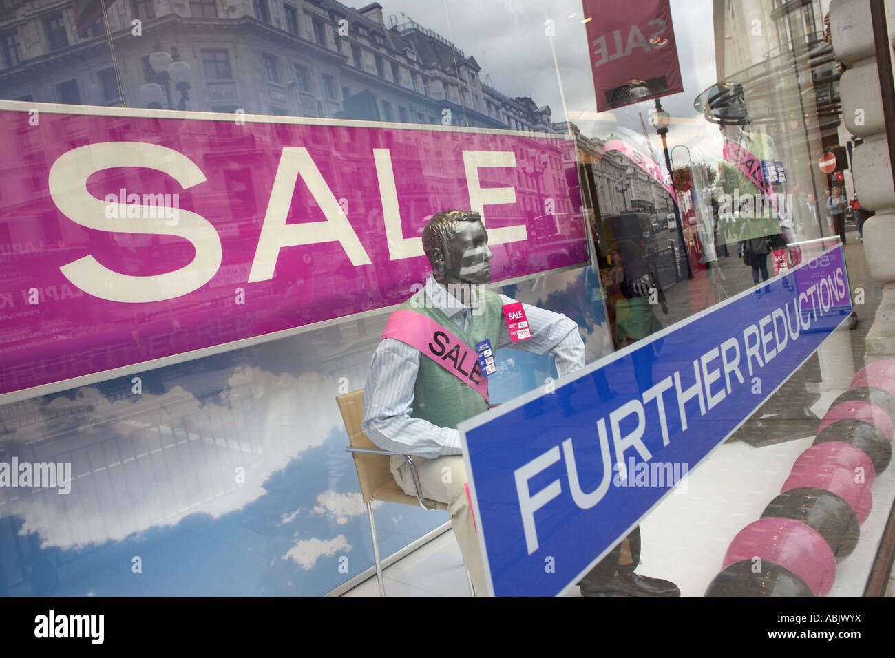 A shop window Sale mannequin, wearing a sash, is in the wide window ...