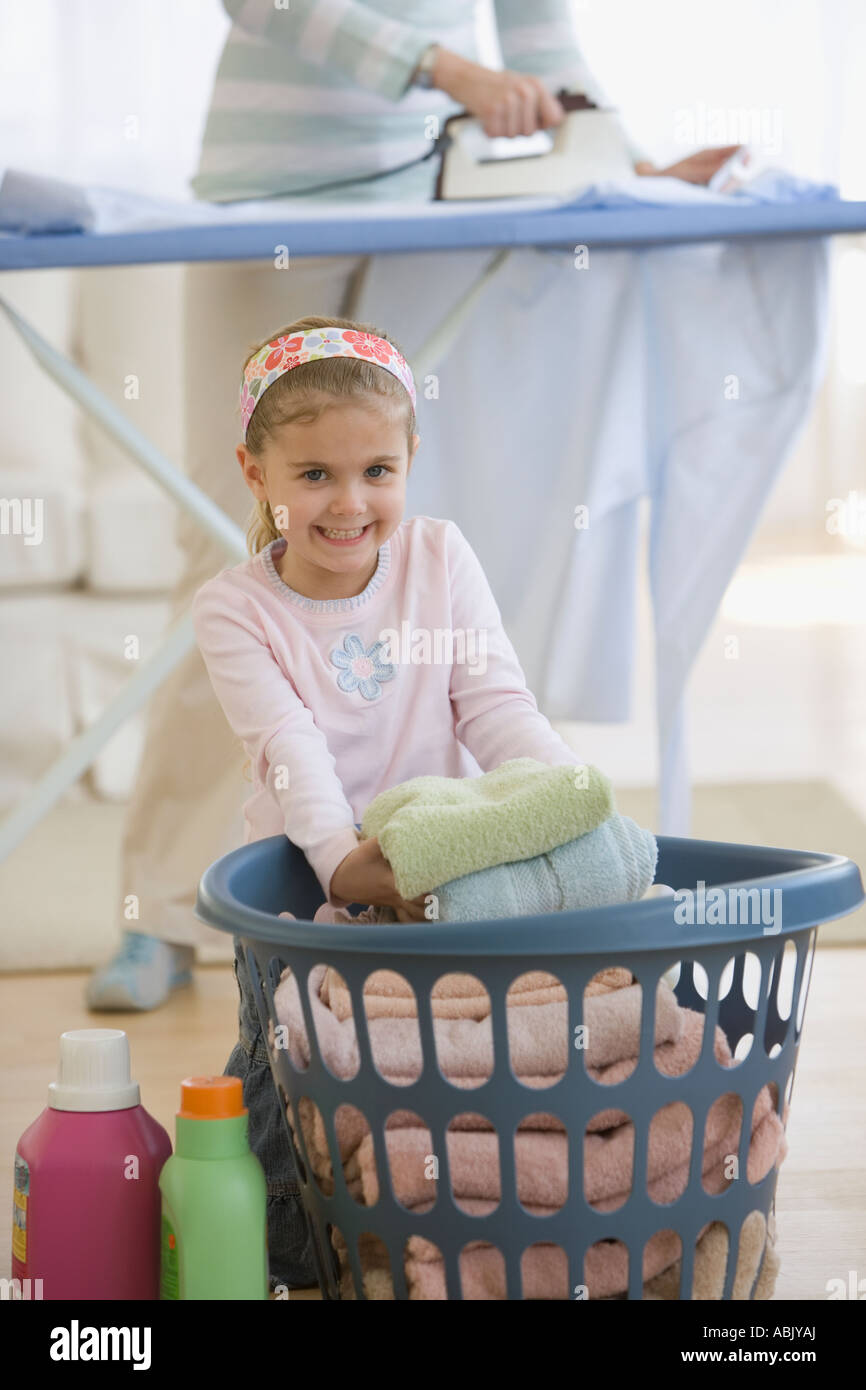 Girl doing laundry with mother Stock Photo - Alamy