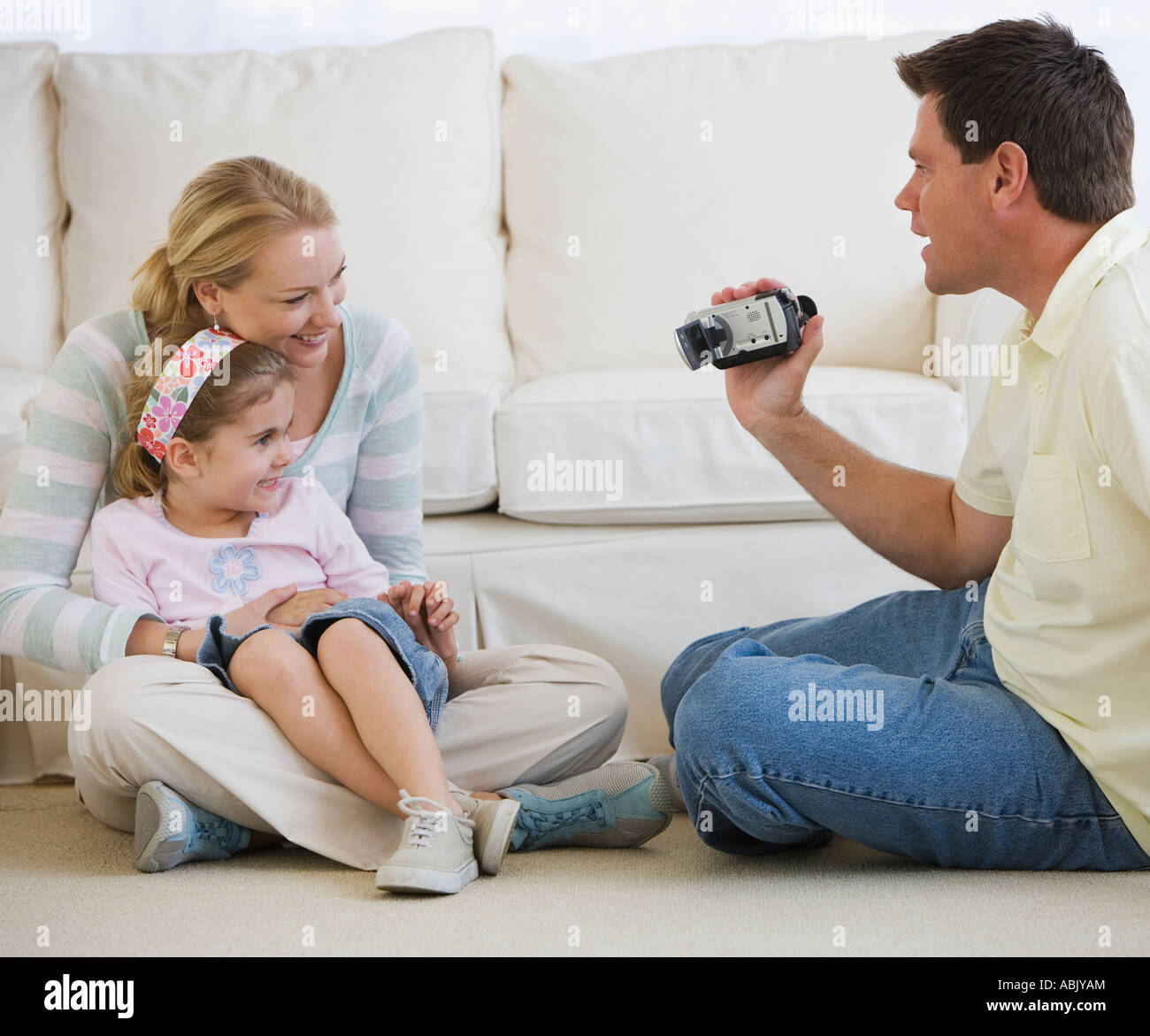 Father video recording mother and daughter Stock Photo - Alamy