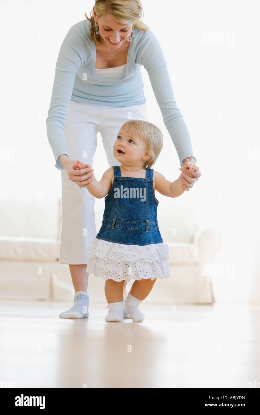 Mother helping baby walk Stock Photo - Alamy