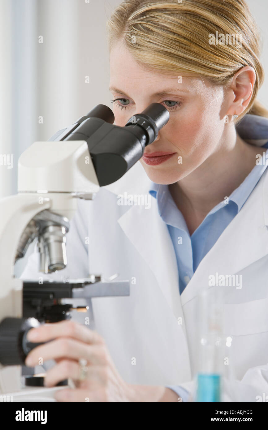 Female scientist looking into microscope Stock Photo - Alamy