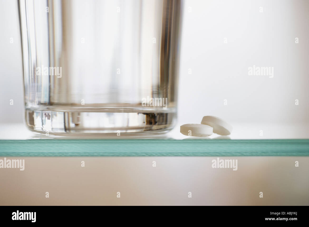Medication and water glass on shelf Stock Photo - Alamy