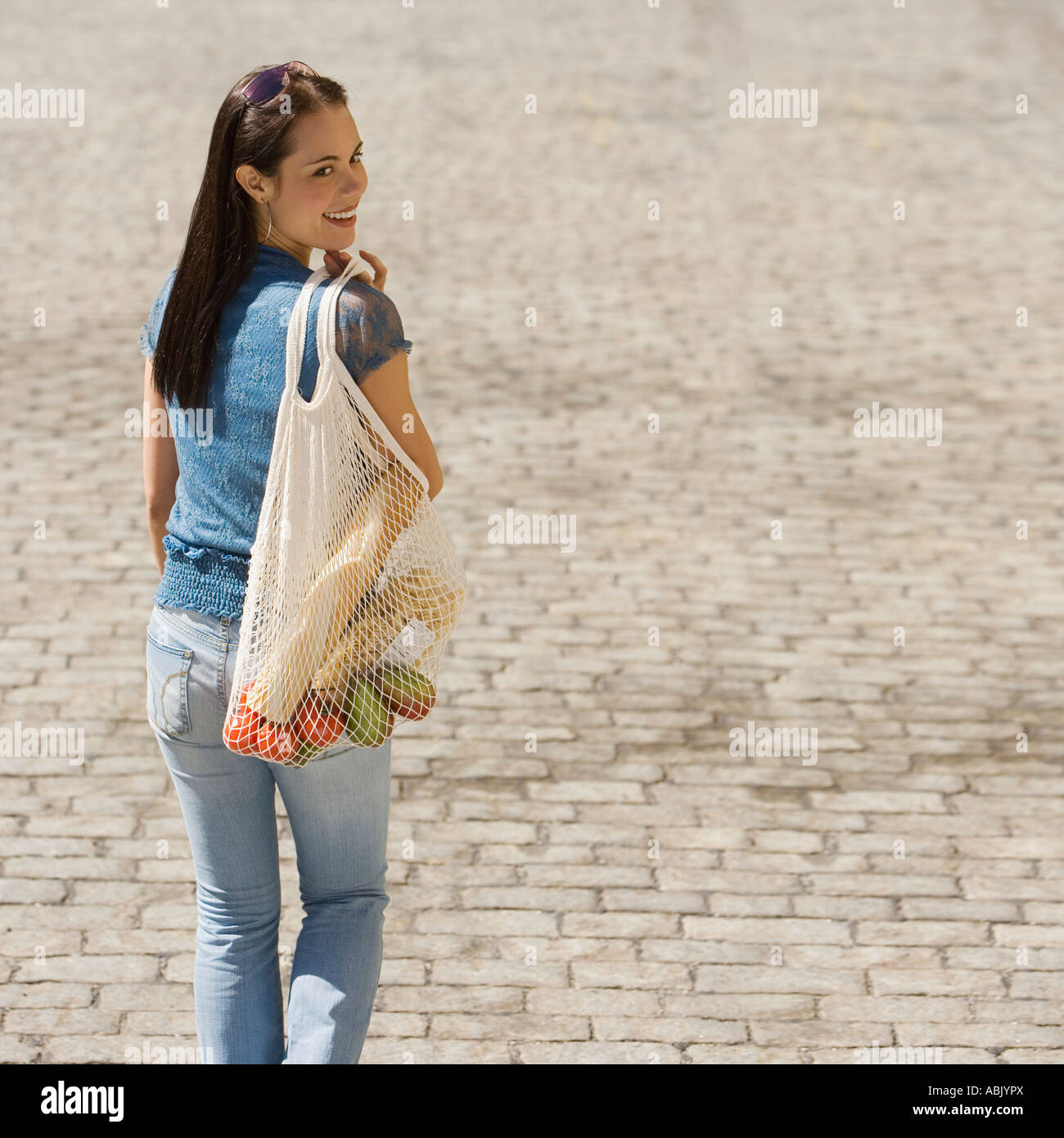 Woman carrying mesh bag of groceries Stock Photo - Alamy
