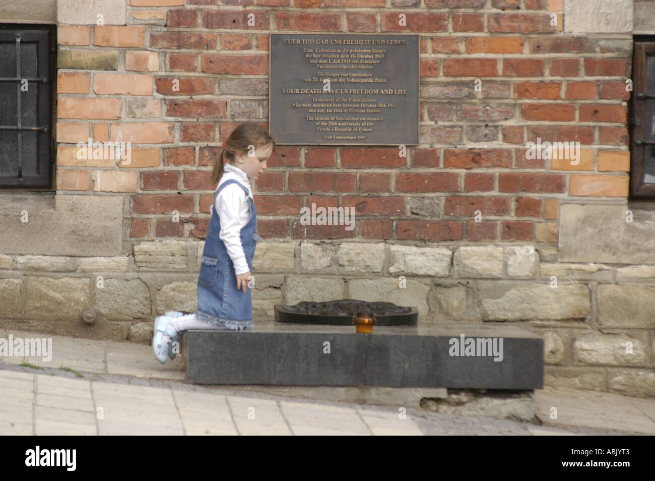 Young Roman Catholic girl praying at war monument Sandomierz Market ...
