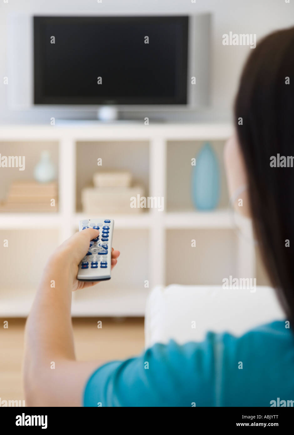 Woman pointing remote control at television Stock Photo - Alamy