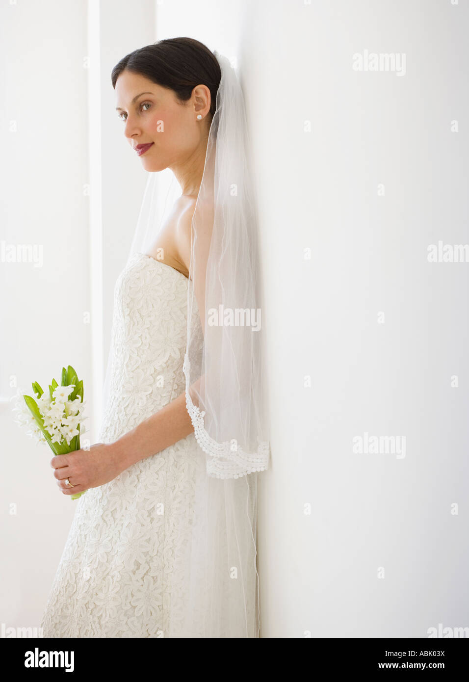 Bride leaning on wall Stock Photo - Alamy