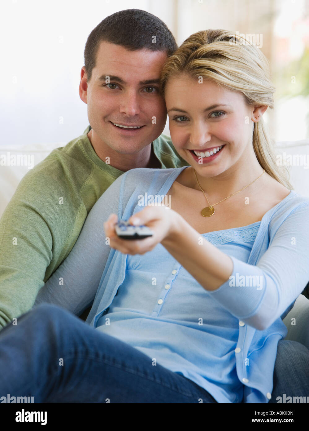 Couple of sofa pointing remote control Stock Photo - Alamy