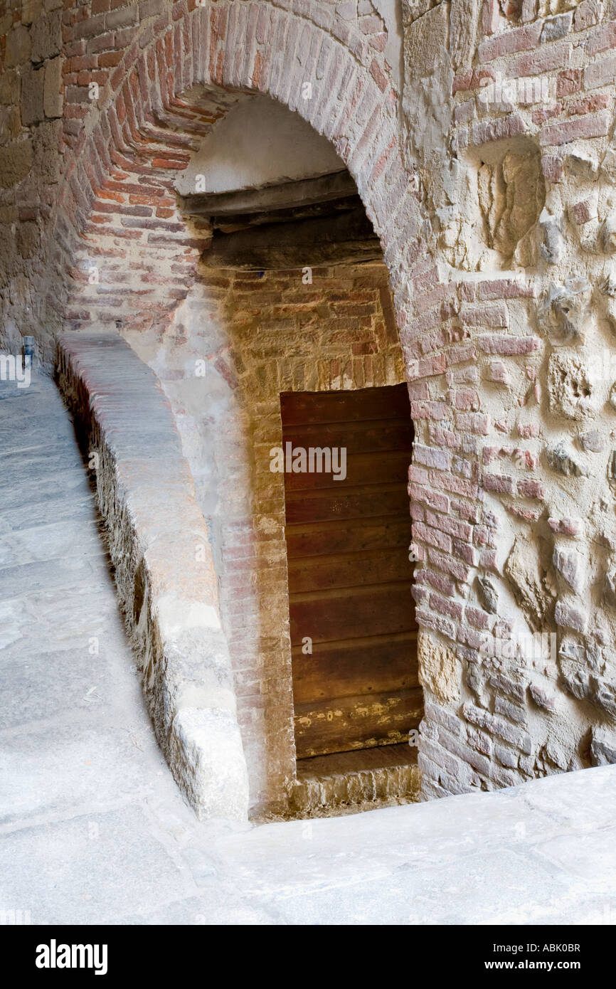 Old stone arch and narrow alleyway with steps in Tuscany hill town ...