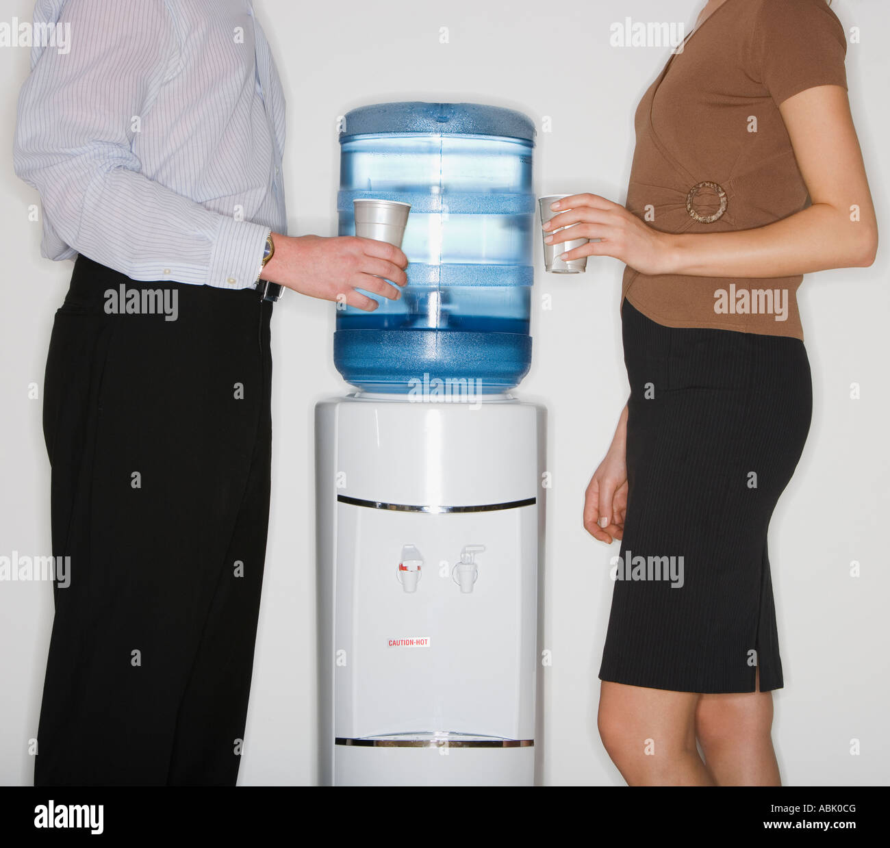 Businesspeople next to water cooler Stock Photo - Alamy