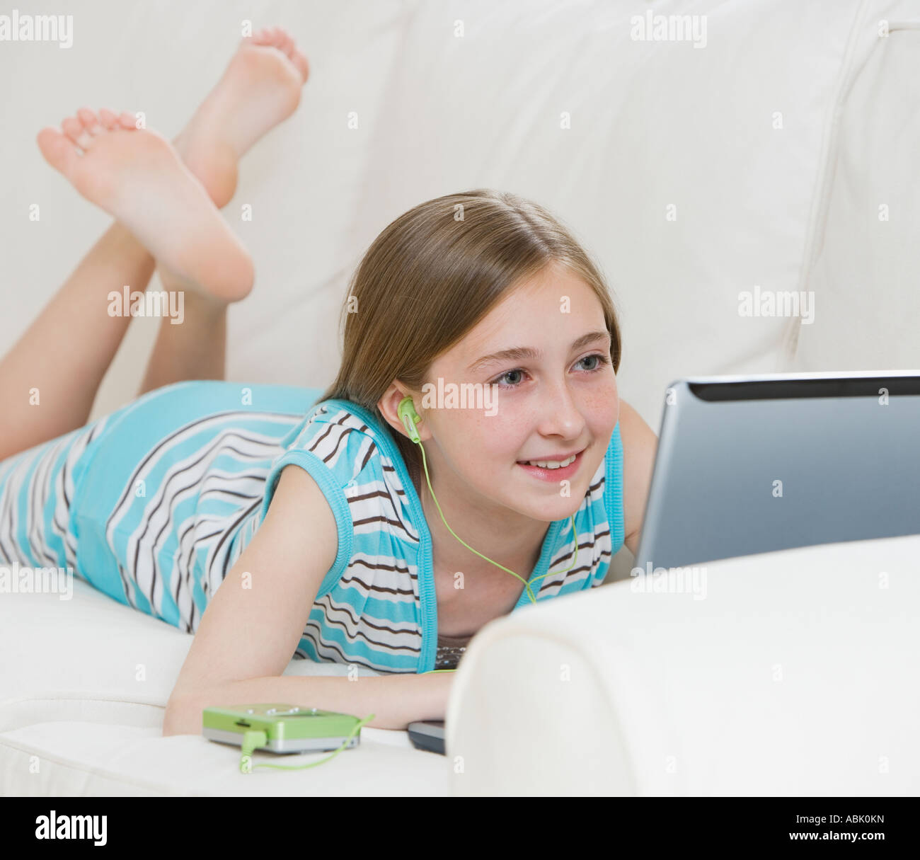 Girl using laptop on sofa Stock Photo - Alamy