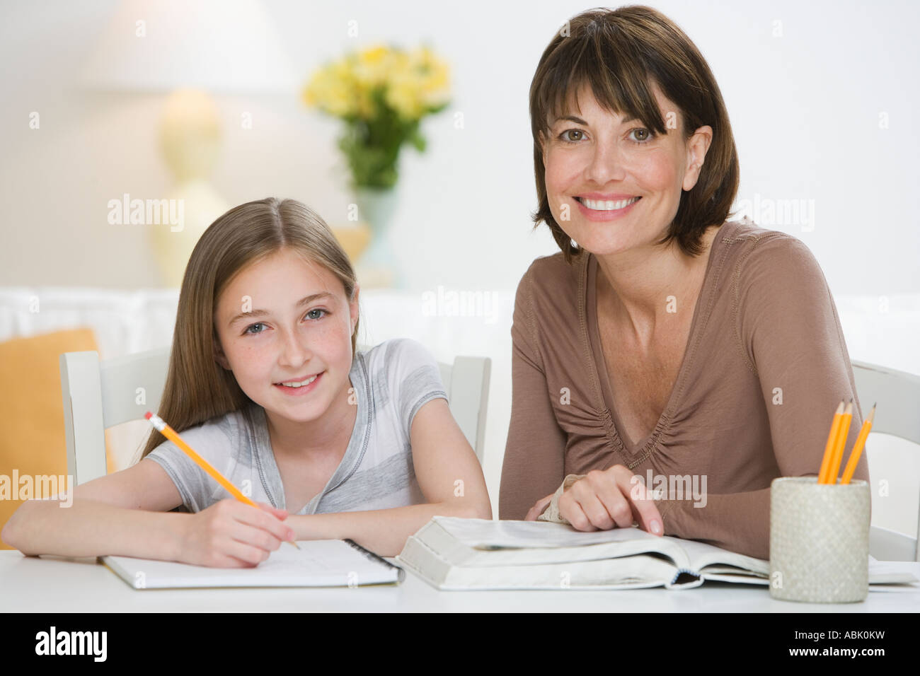 Mother helping daughter with homework Stock Photo - Alamy