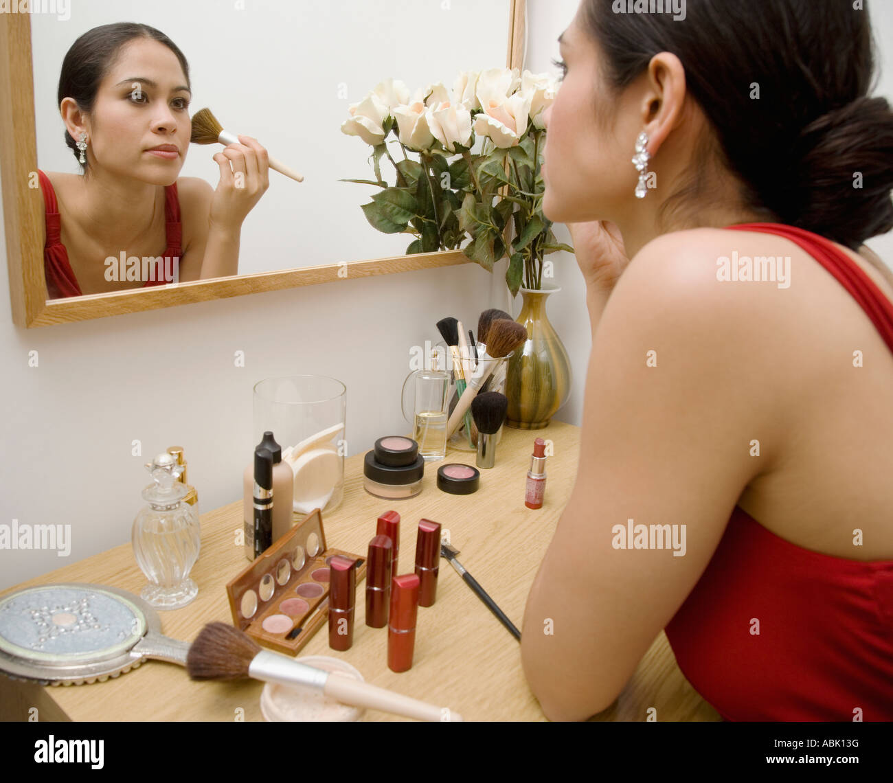 Woman applying makeup in mirror Stock Photo - Alamy