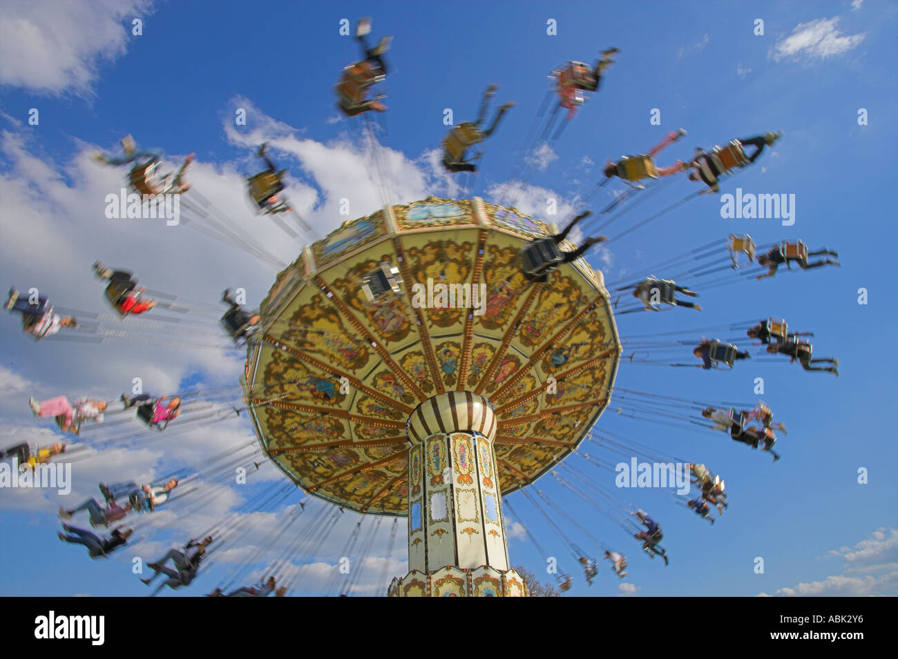 Tilting carousel rotating at speed with blurred riders Stock Photo - Alamy