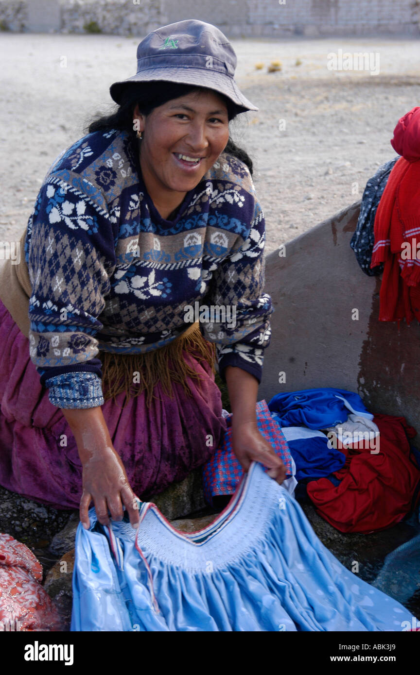 BOL Bolivia Aymara woman washing clothes in turco village Altiplano ...