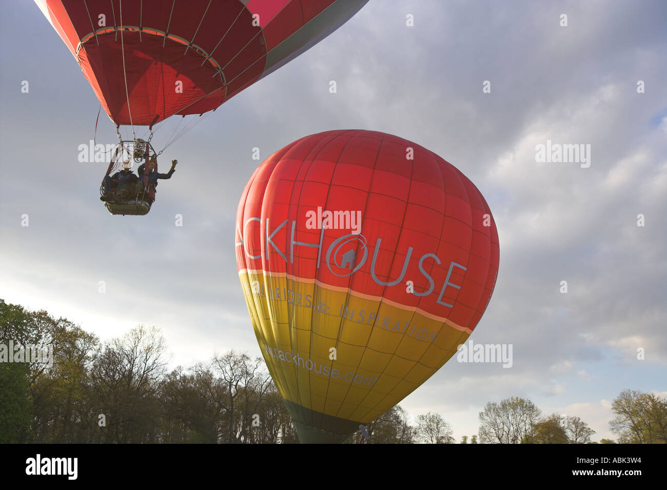 Balloonist waves to onlookers as hot air balloon rises Stock Photo - Alamy